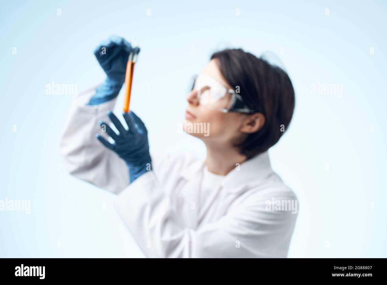 female laboratory assistant in white coat chemical solution test tube ...