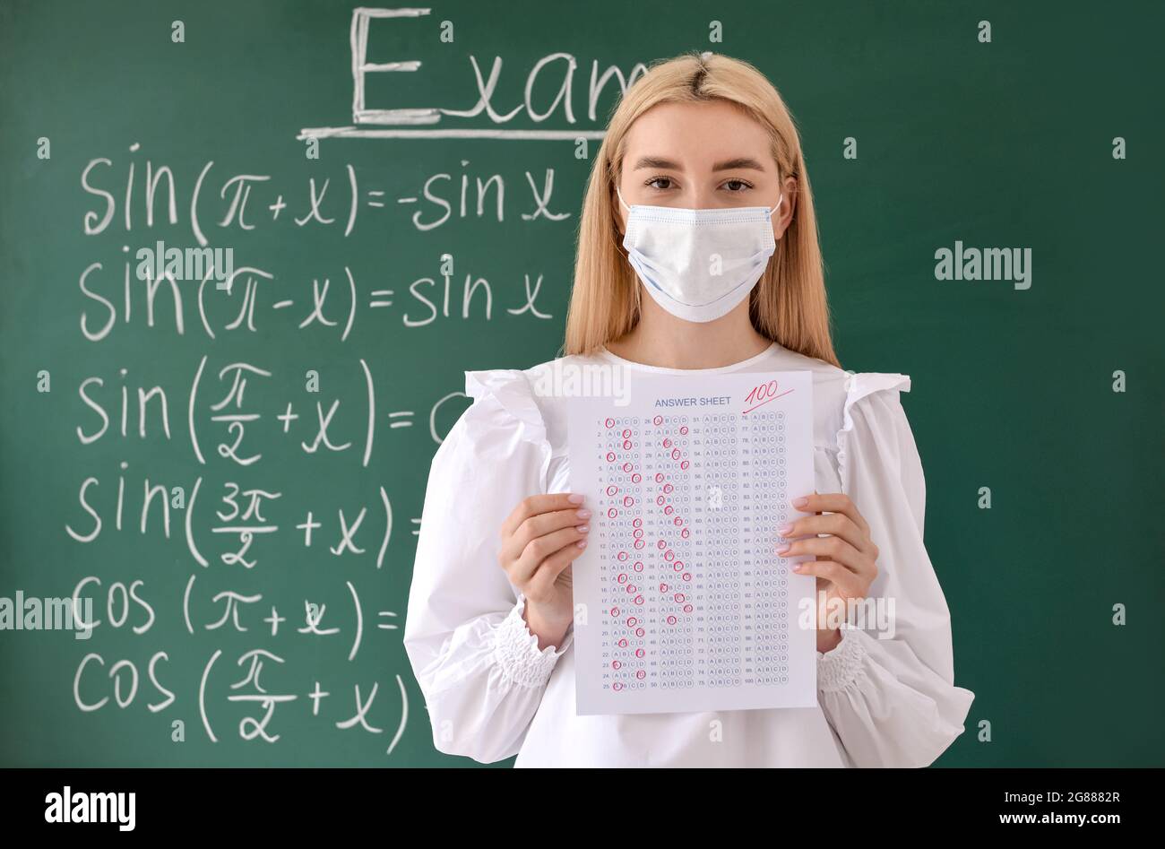 Student with answer sheet for school test near blackboard Stock Photo ...