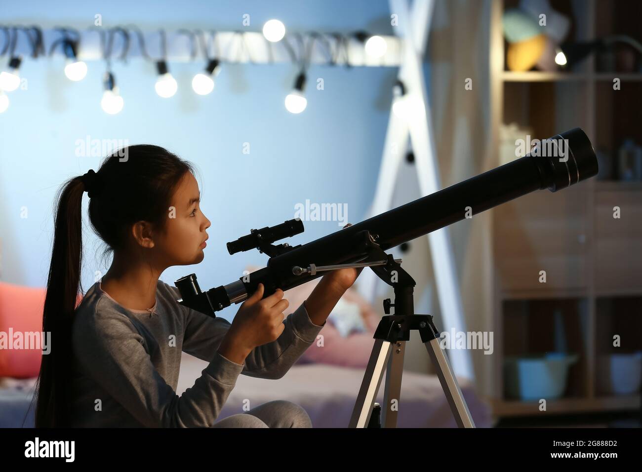 Cute little girl with telescope looking at stars in evening Stock Photo ...