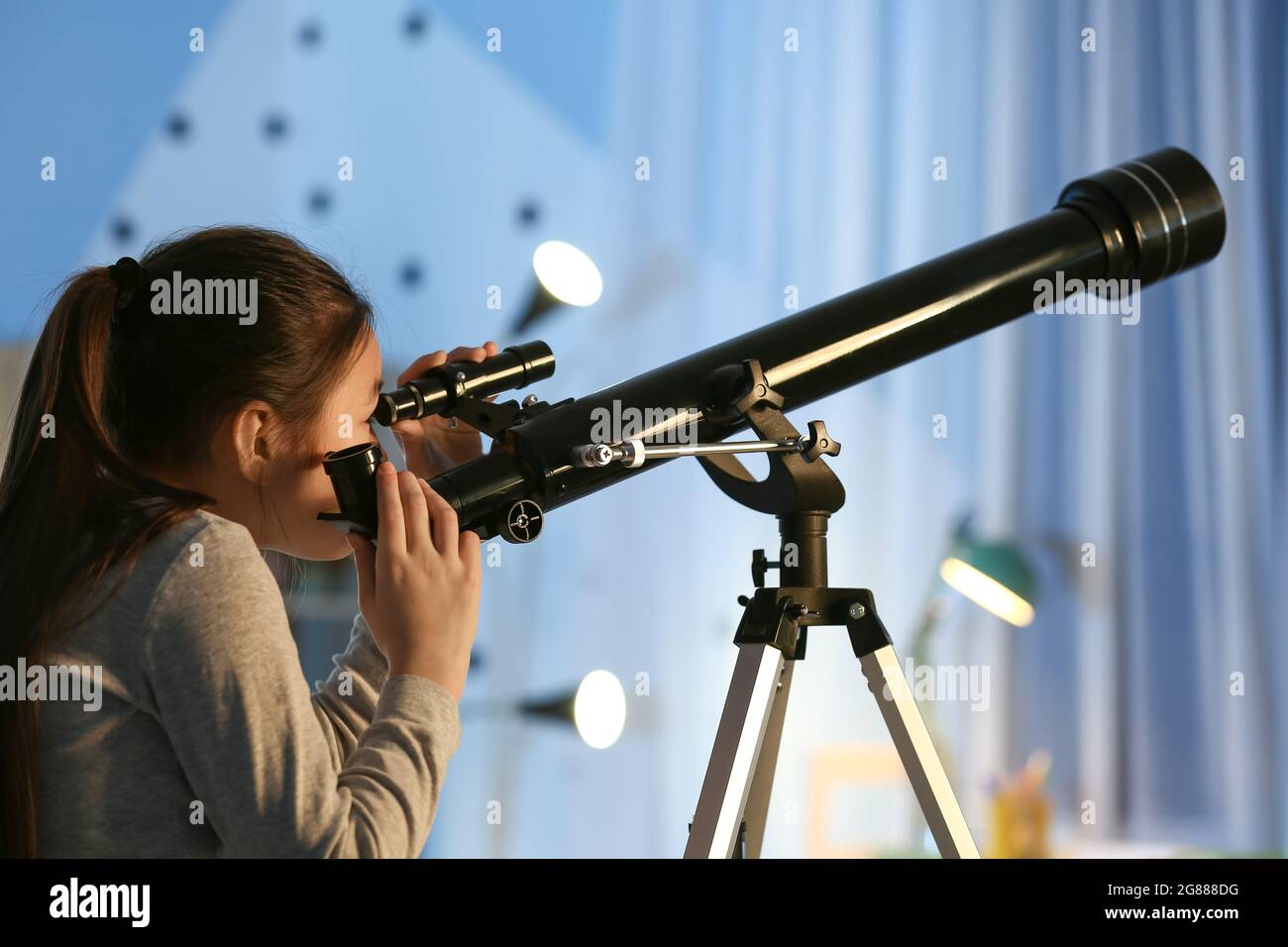 Cute little girl with telescope looking at stars in evening Stock Photo ...