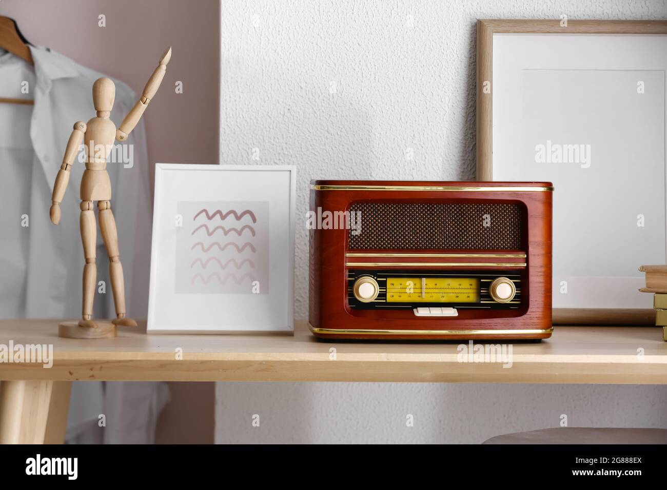 Retro radio receiver with frames and mannequin on table in room Stock ...