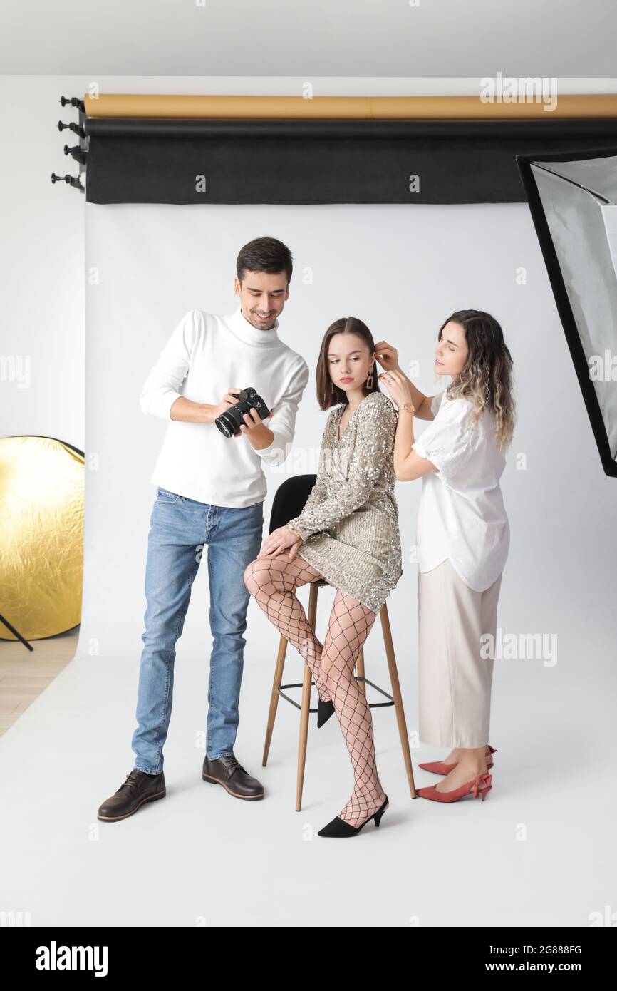 Stylist and photographer working with model in studio Stock Photo - Alamy