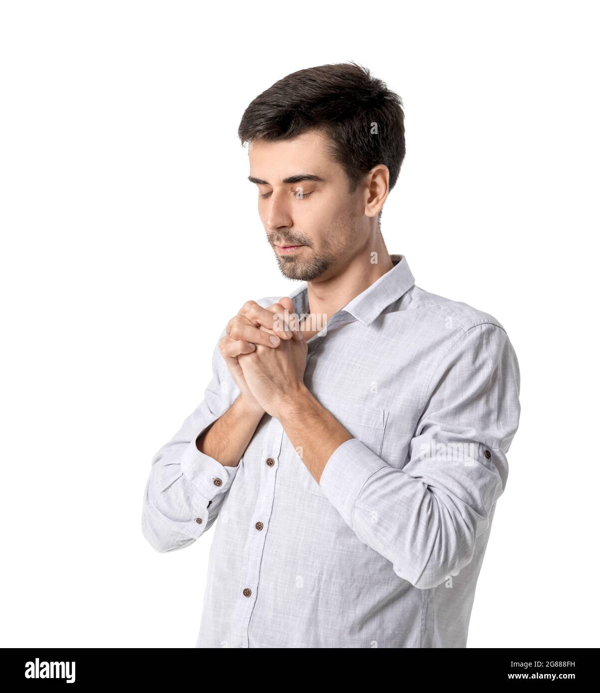 Religious young man praying on white background Stock Photo - Alamy