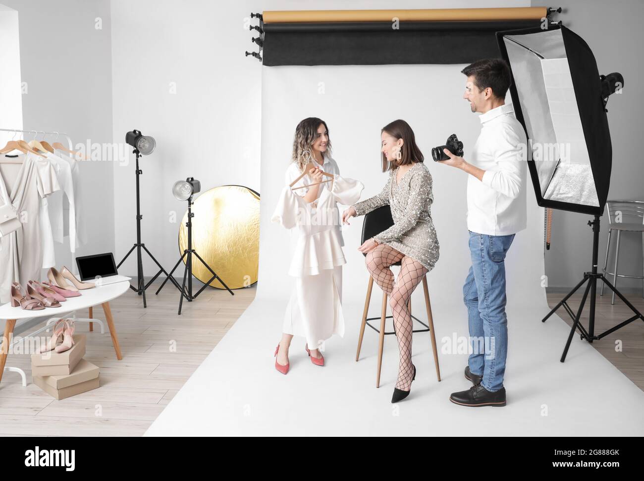 Stylist and photographer working with model in studio Stock Photo - Alamy
