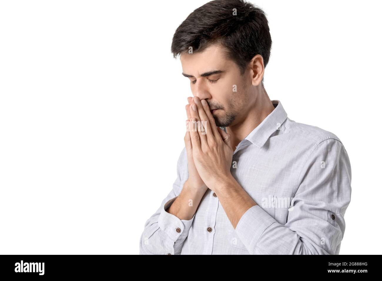 Religious young man praying on white background Stock Photo - Alamy