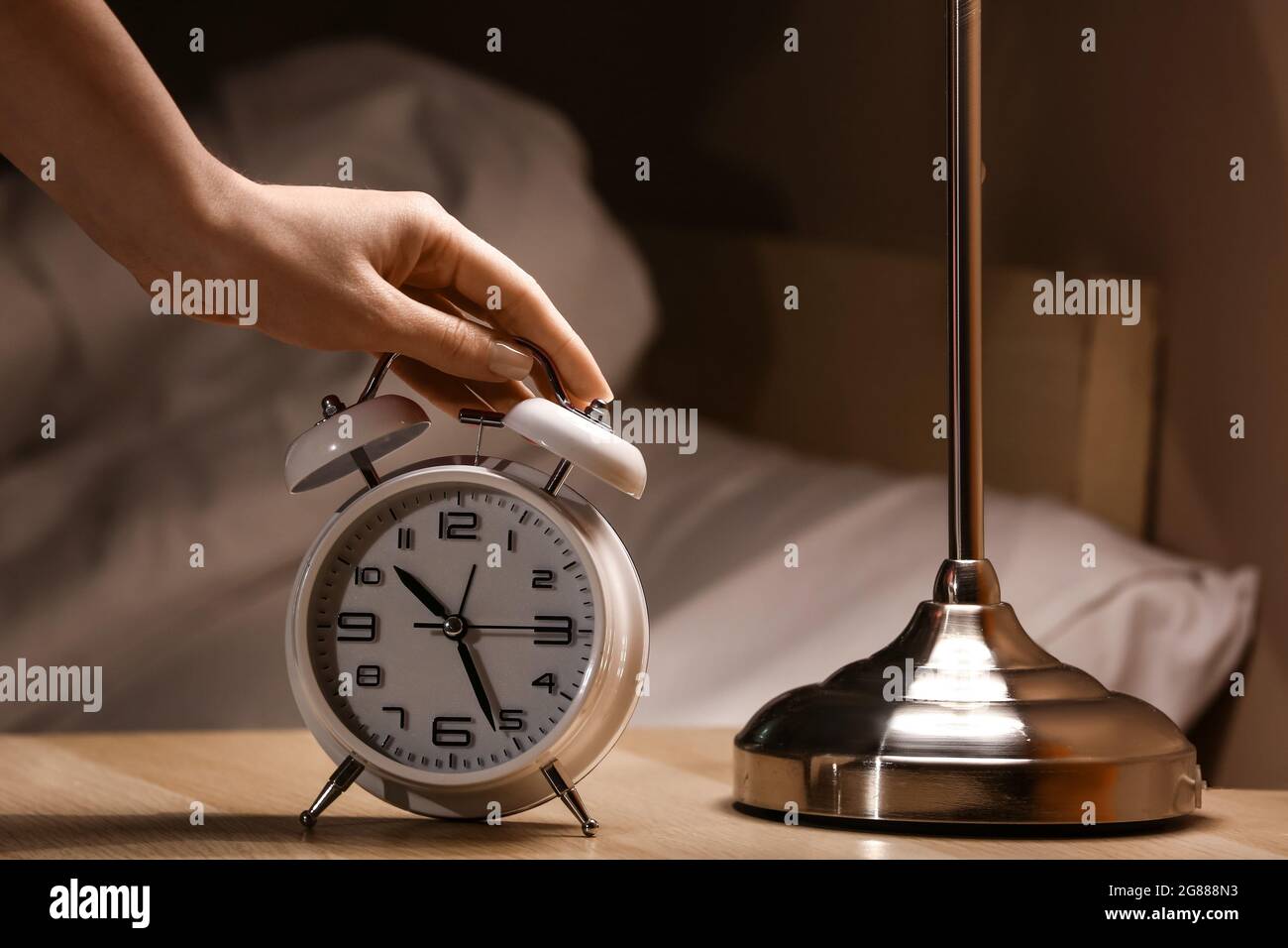 Woman turning off alarm clock in bedroom at night, closeup Stock Photo ...