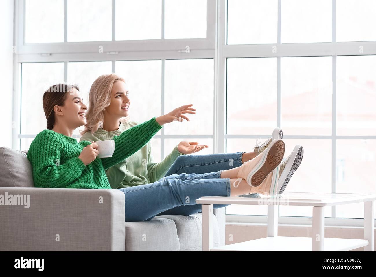Beautiful young sisters drinking tea at home Stock Photo - Alamy