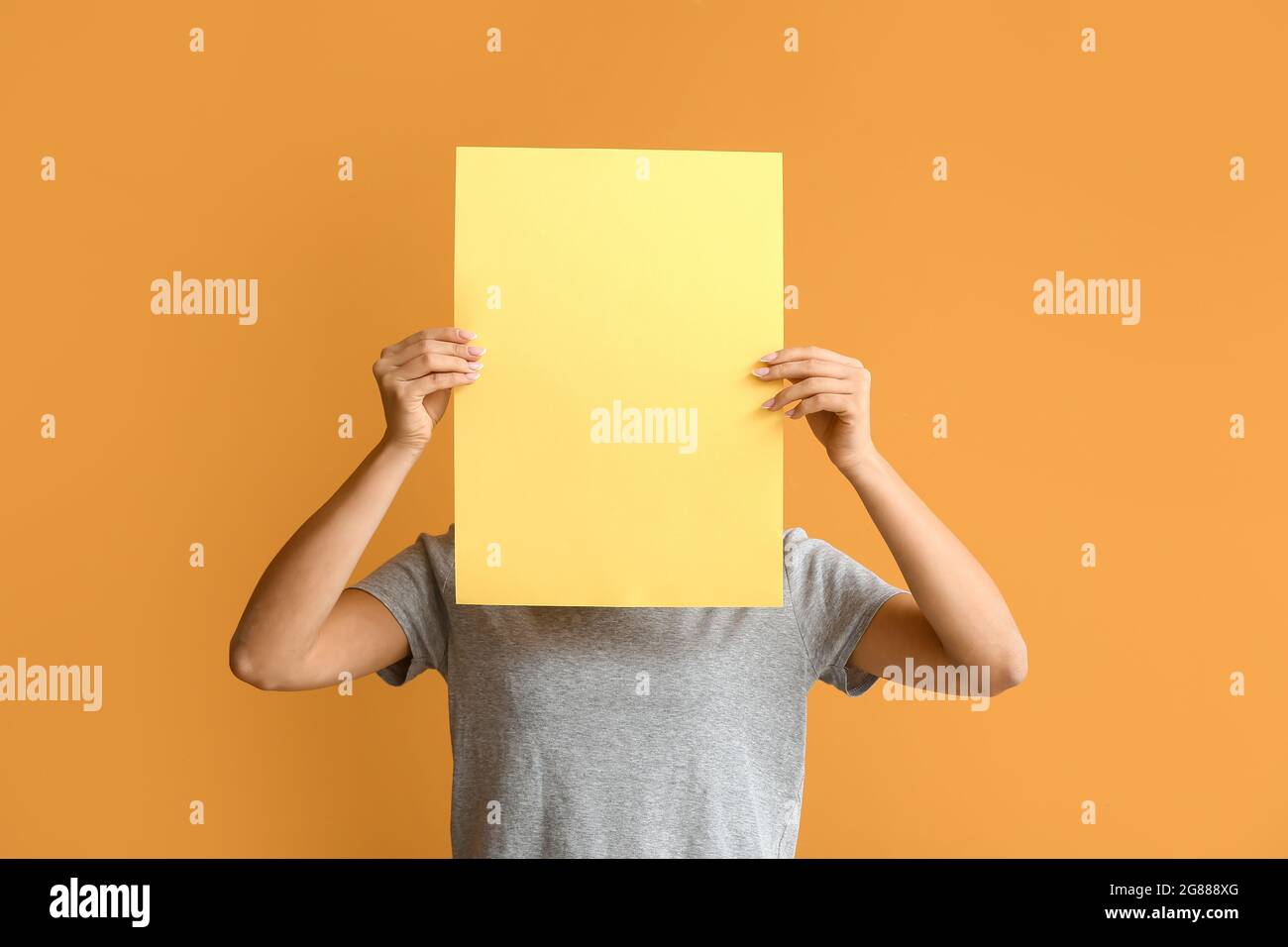 Young woman with blank paper sheet on color background Stock Photo - Alamy
