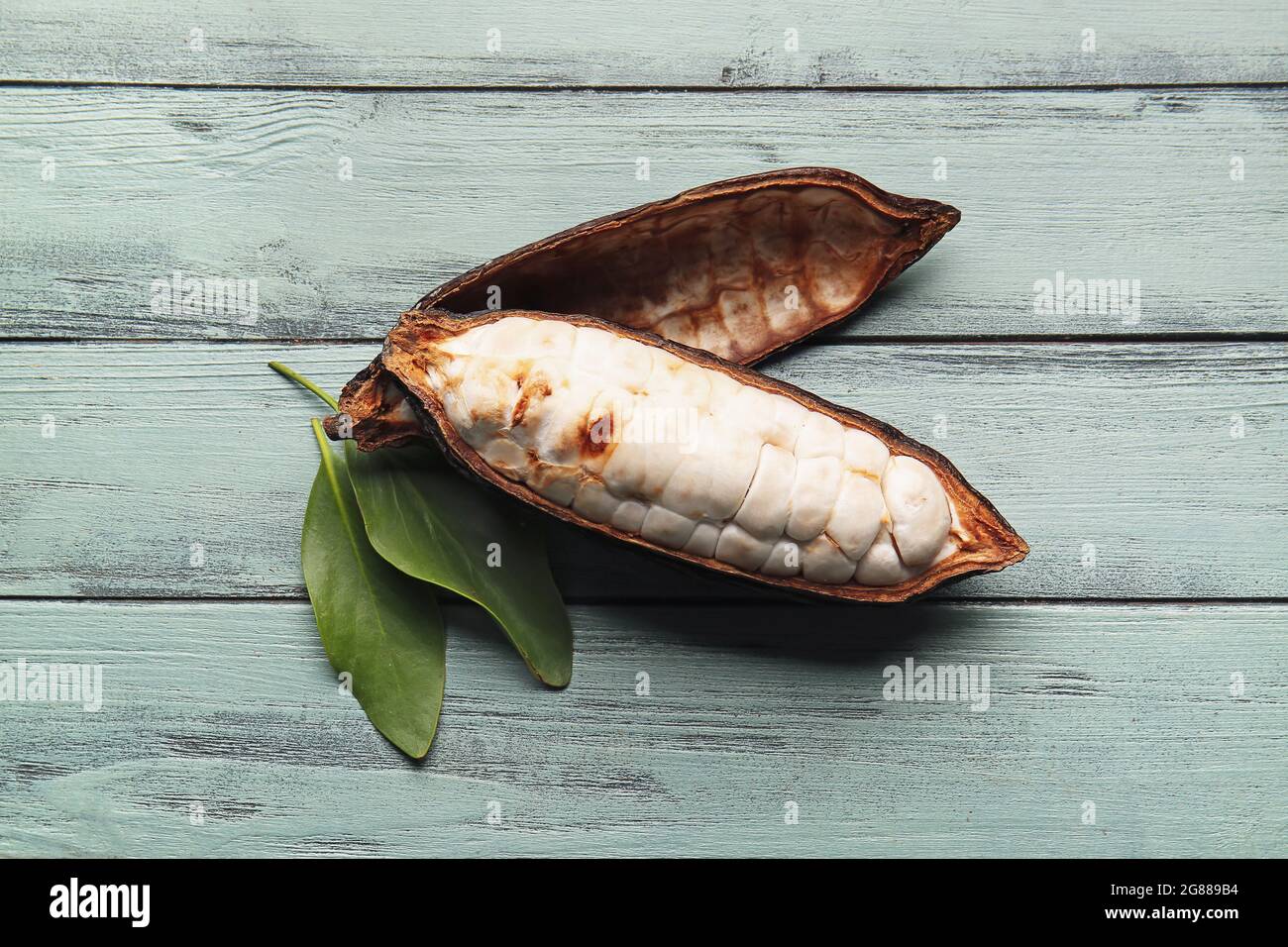 Half of fresh cocoa fruit on color wooden background Stock Photo - Alamy