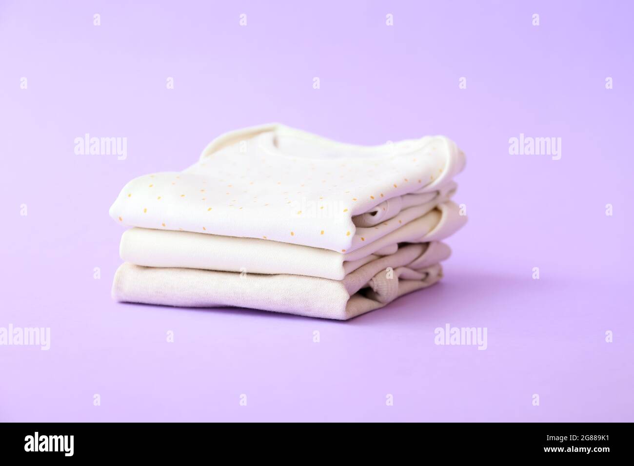 Stack of baby clothes on color background Stock Photo - Alamy
