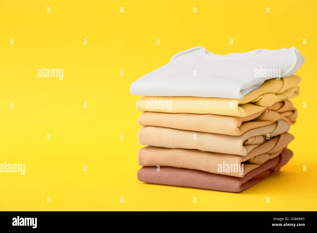 Stack of baby clothes on color background Stock Photo - Alamy