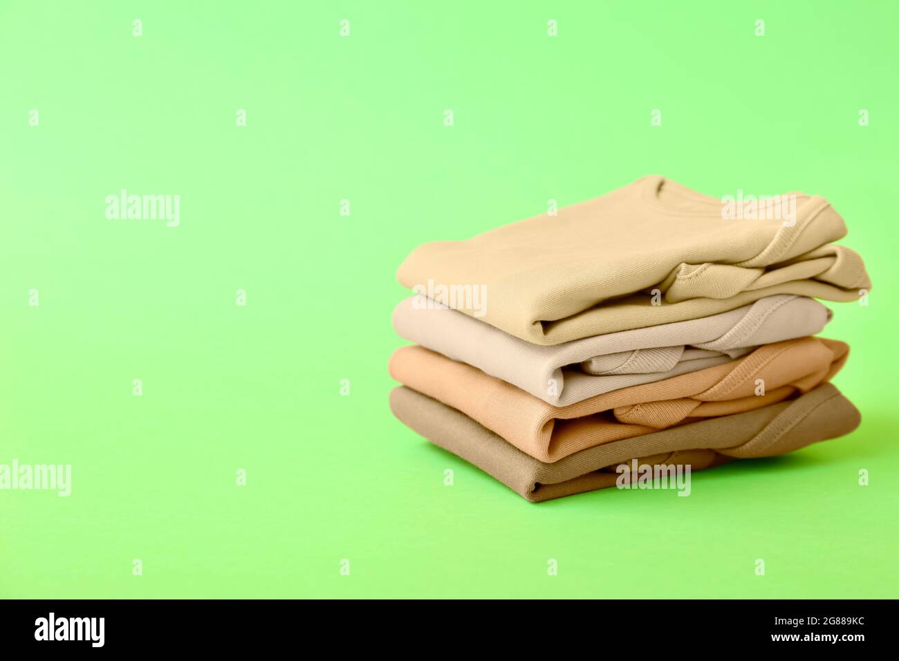 Stack of baby clothes on color background Stock Photo - Alamy