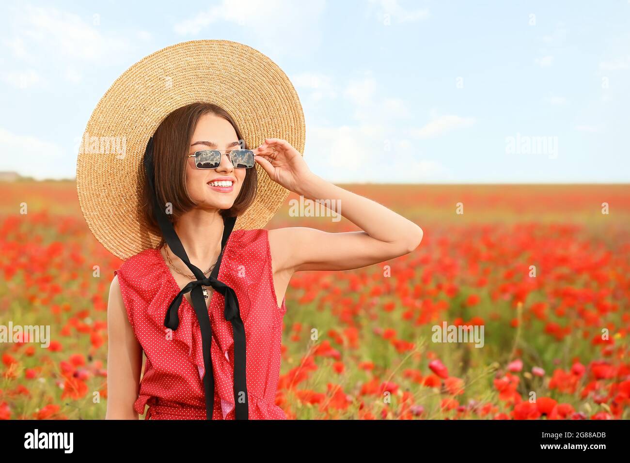 Beautiful young woman in poppy field Stock Photo - Alamy