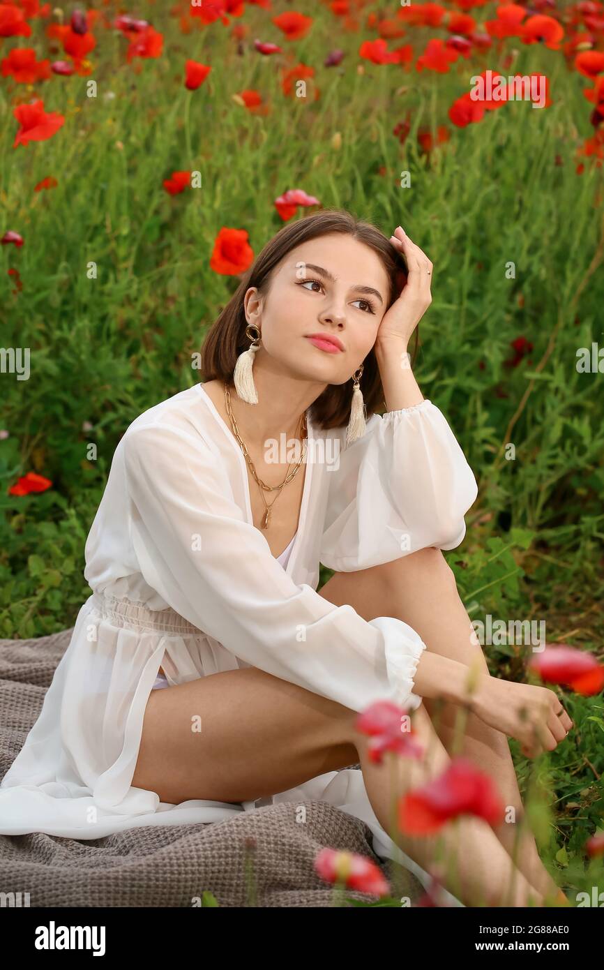 Beautiful woman sitting in poppy hi-res stock photography and images ...