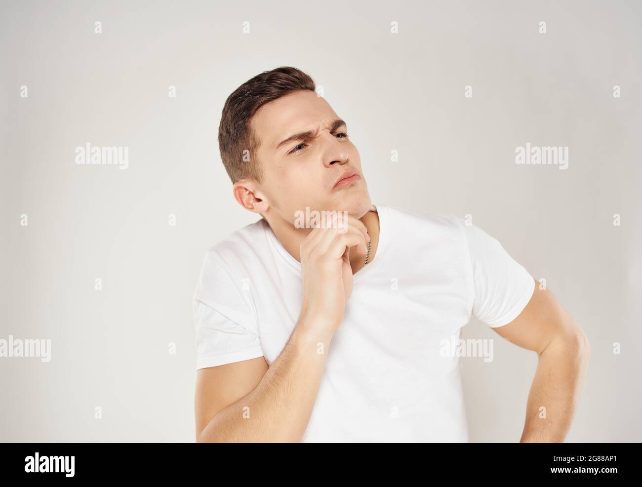 man with pensive facial expression in white t-shirt emotions isolated ...