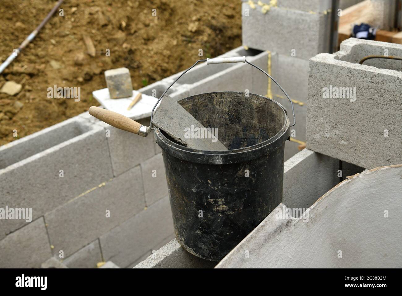 Hod bucket, mortar and mortar trowel on construction site homemade ...