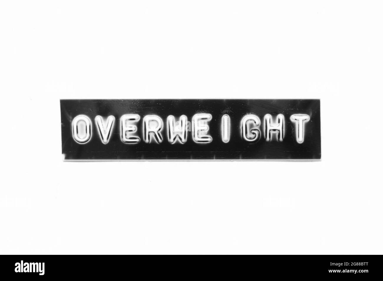 Embossed letter with word overweight in black banner on white paper ...