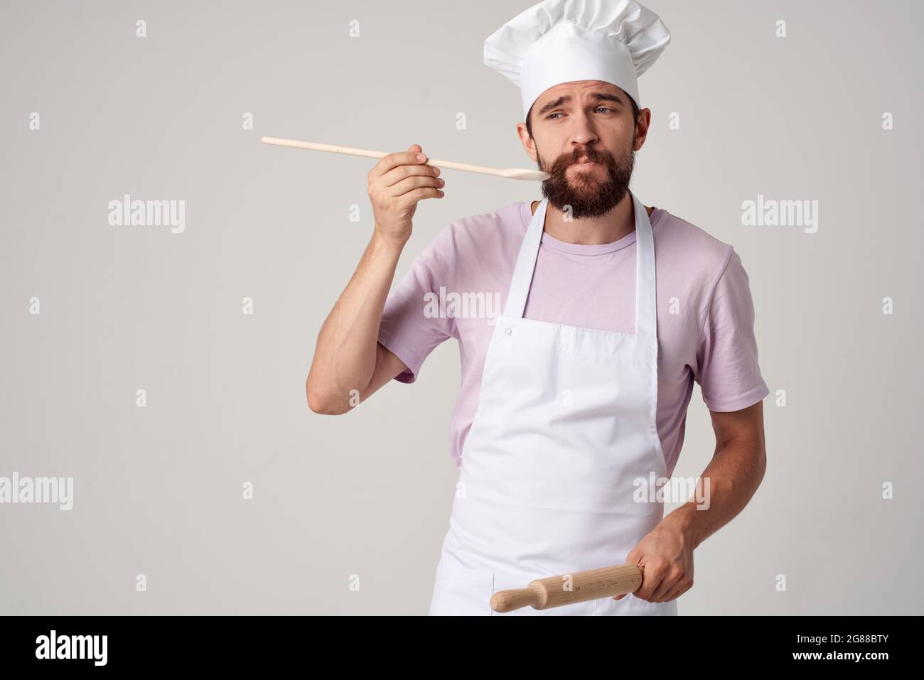 professional chef in uniform with a spoon in his hands work light ...