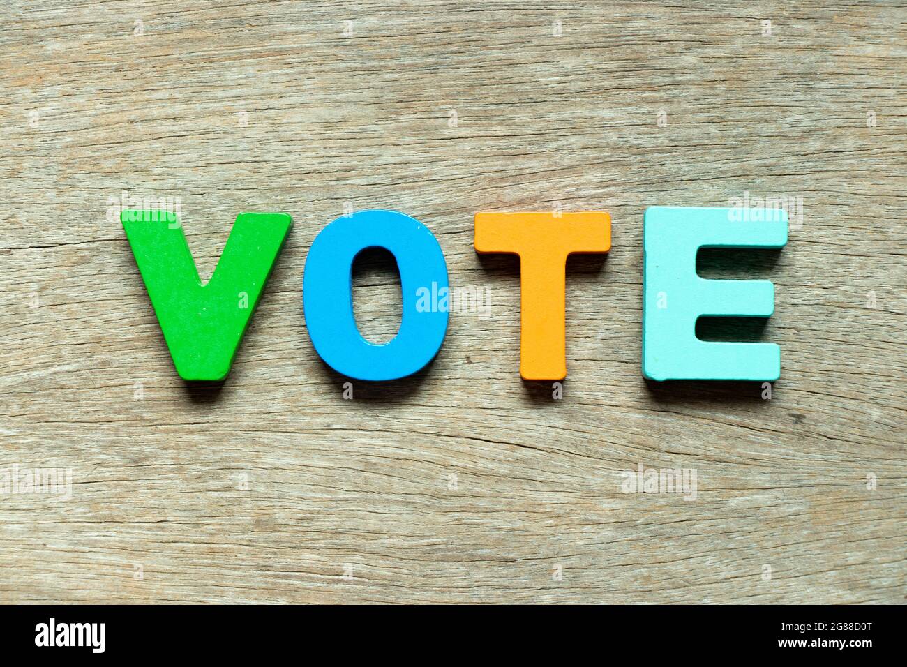 Color alphabet letter in word vote on wood background Stock Photo - Alamy