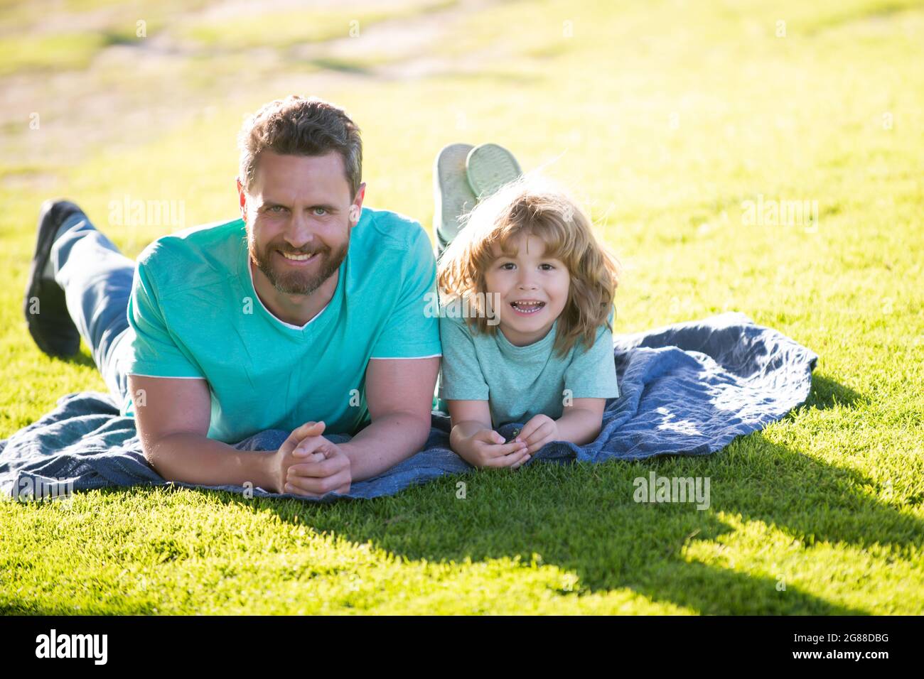 Father and son relaxing on nature in park. Childhood and parenthood ...