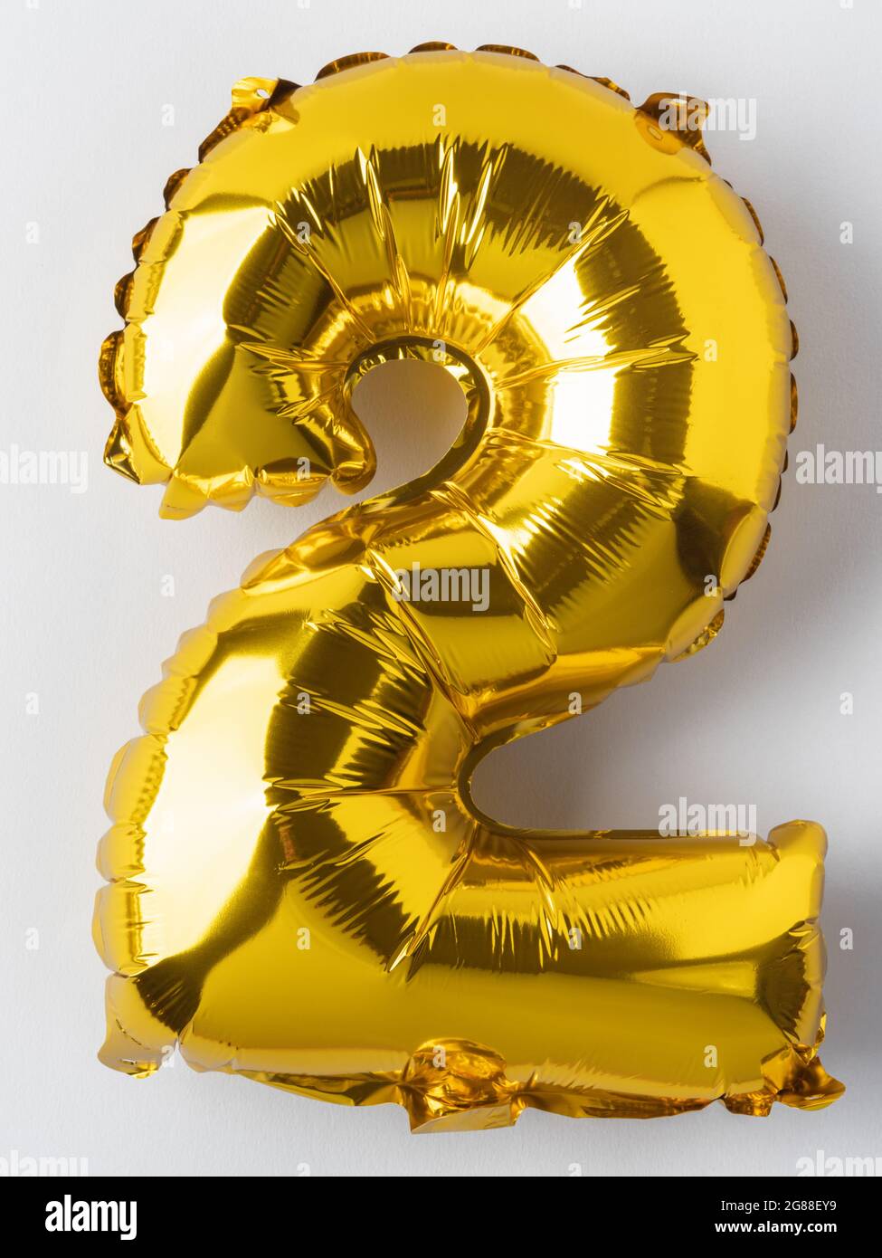 Number 2 golden foil balloon party decor on gray background, birthday ...