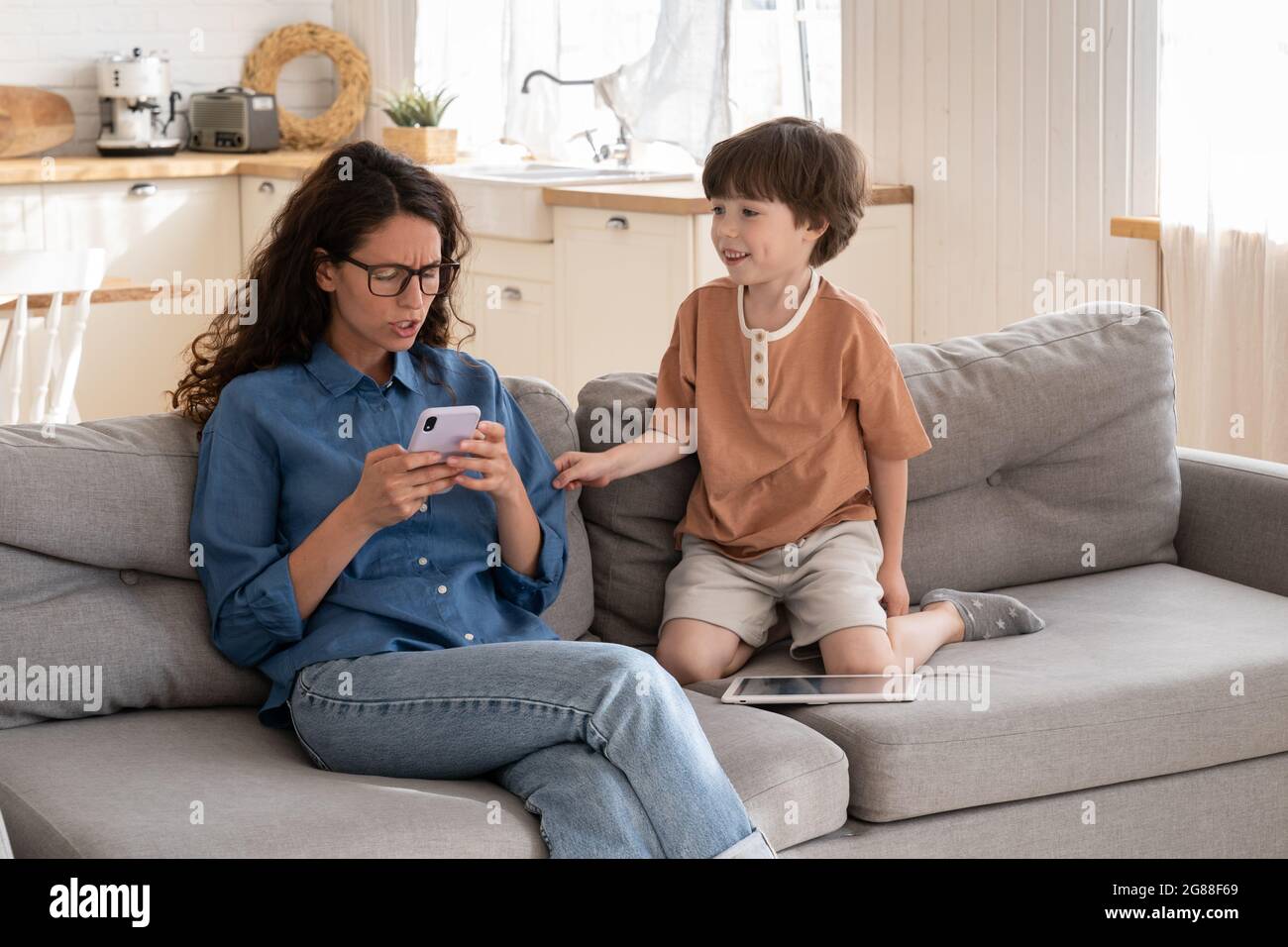 Indifferent mother surf social media irritated with distracting bored ...