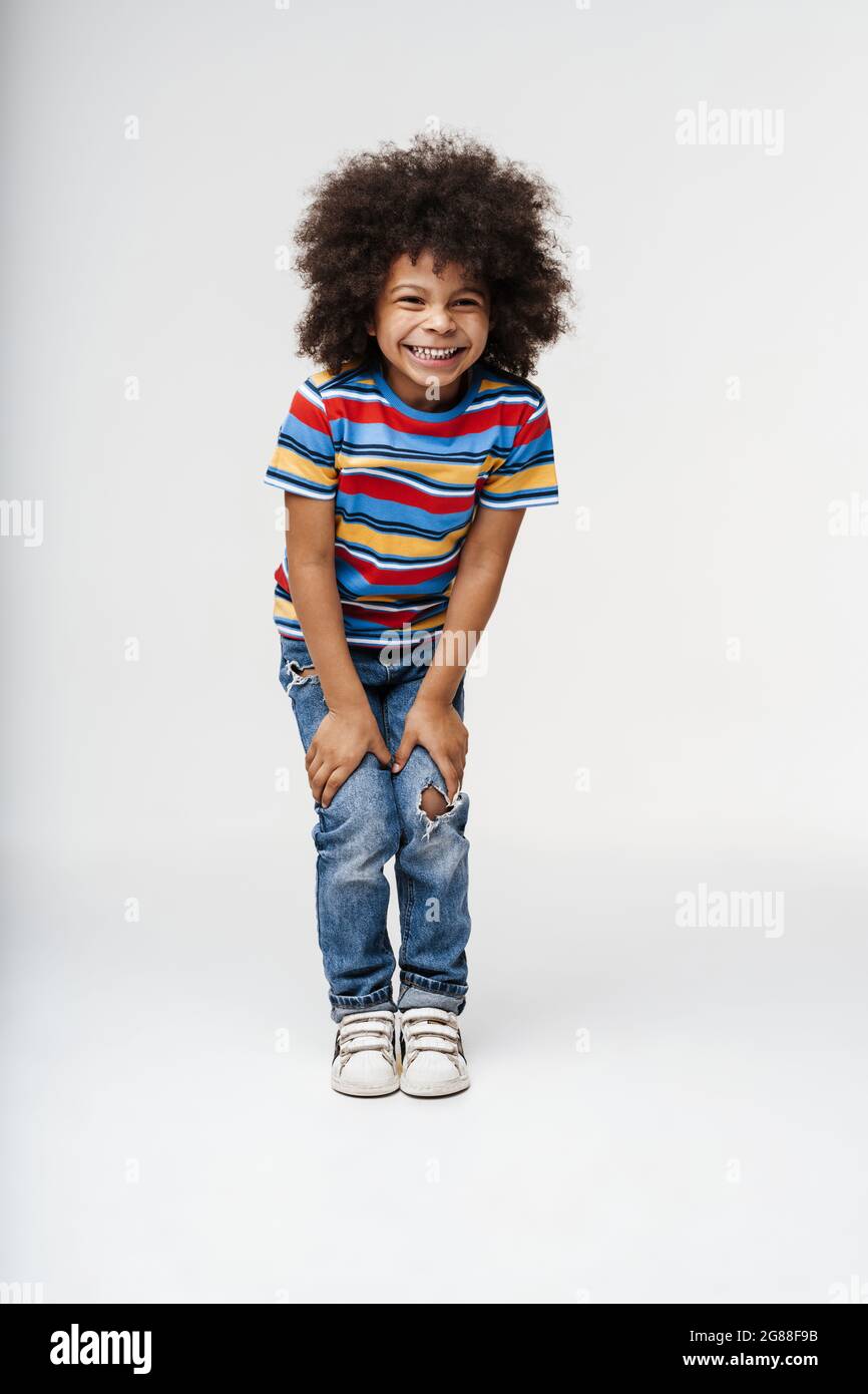 Happy preschooler african boy standing over white wall, having fun ...