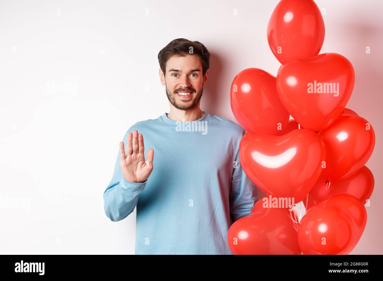 Handsome boyfriend saying hello, bring romantic red heart balloons on ...