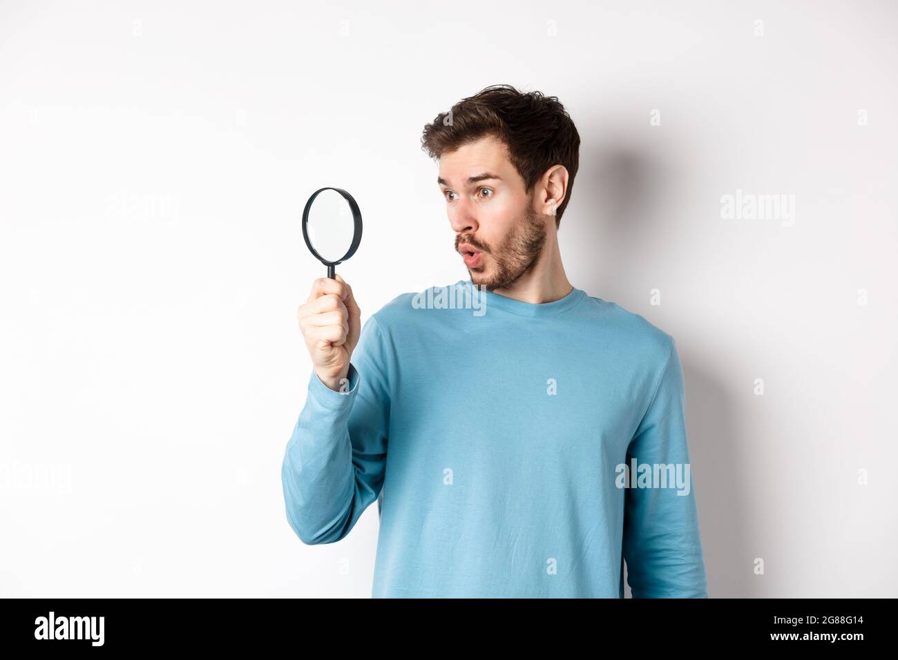 Man got surprised while looking through magnifying glass, saying wow at ...