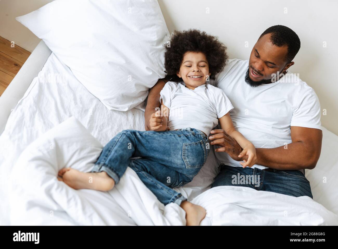 Black father and son laughing while making fun in bed at home Stock ...