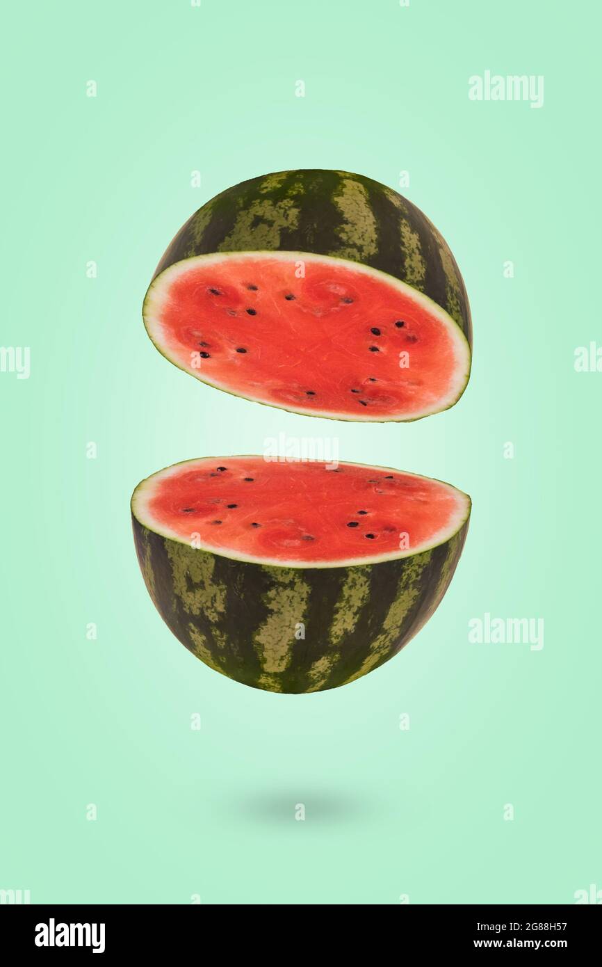 Ripe watermelon cut in half flying in the air. Floating, flying ...