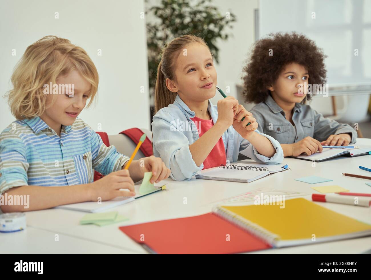 Education is key. Lovely diverse kids studying and making notes while ...