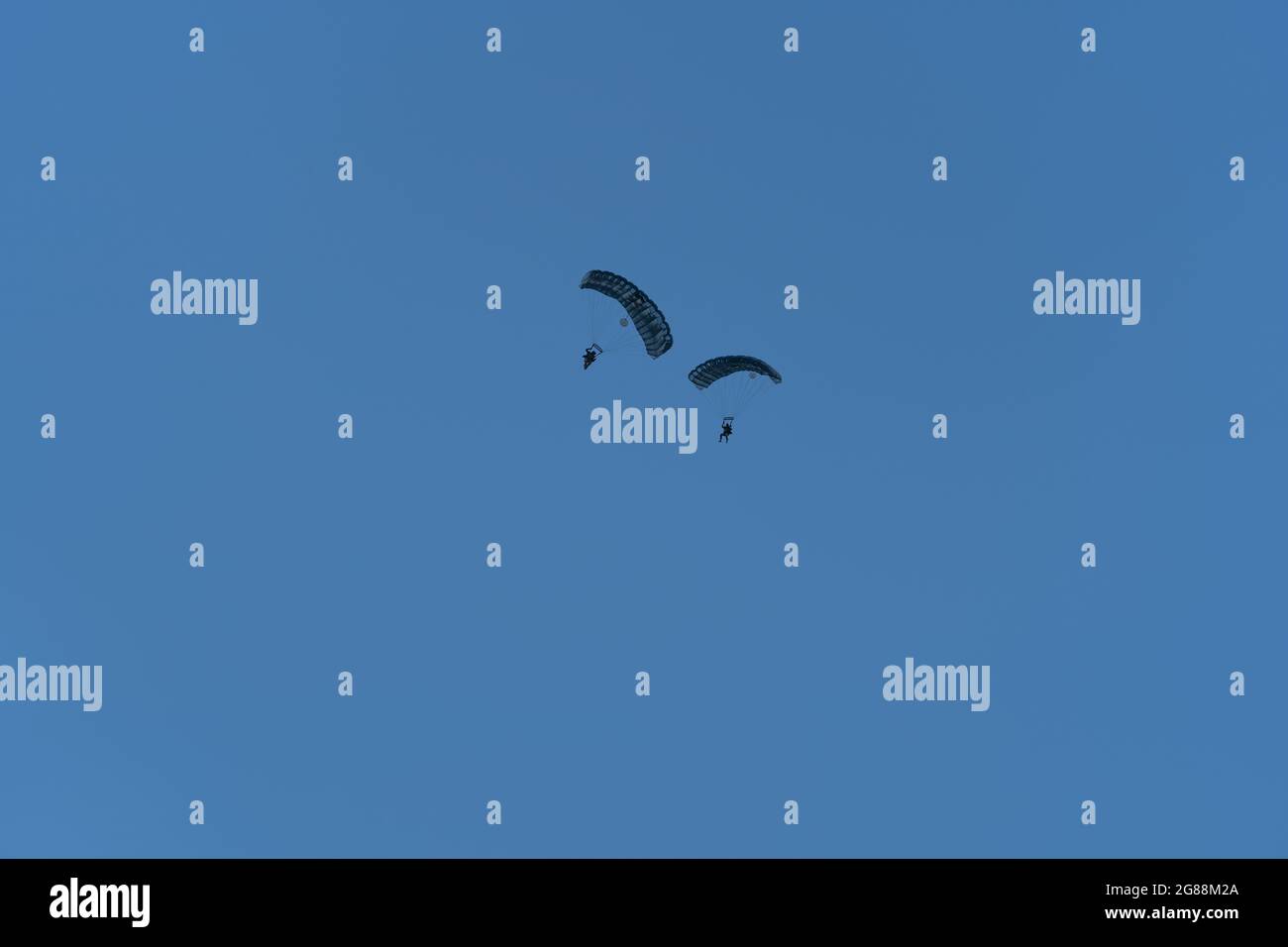 Soldiers parachuting exercises on a blue sky background Stock Photo - Alamy