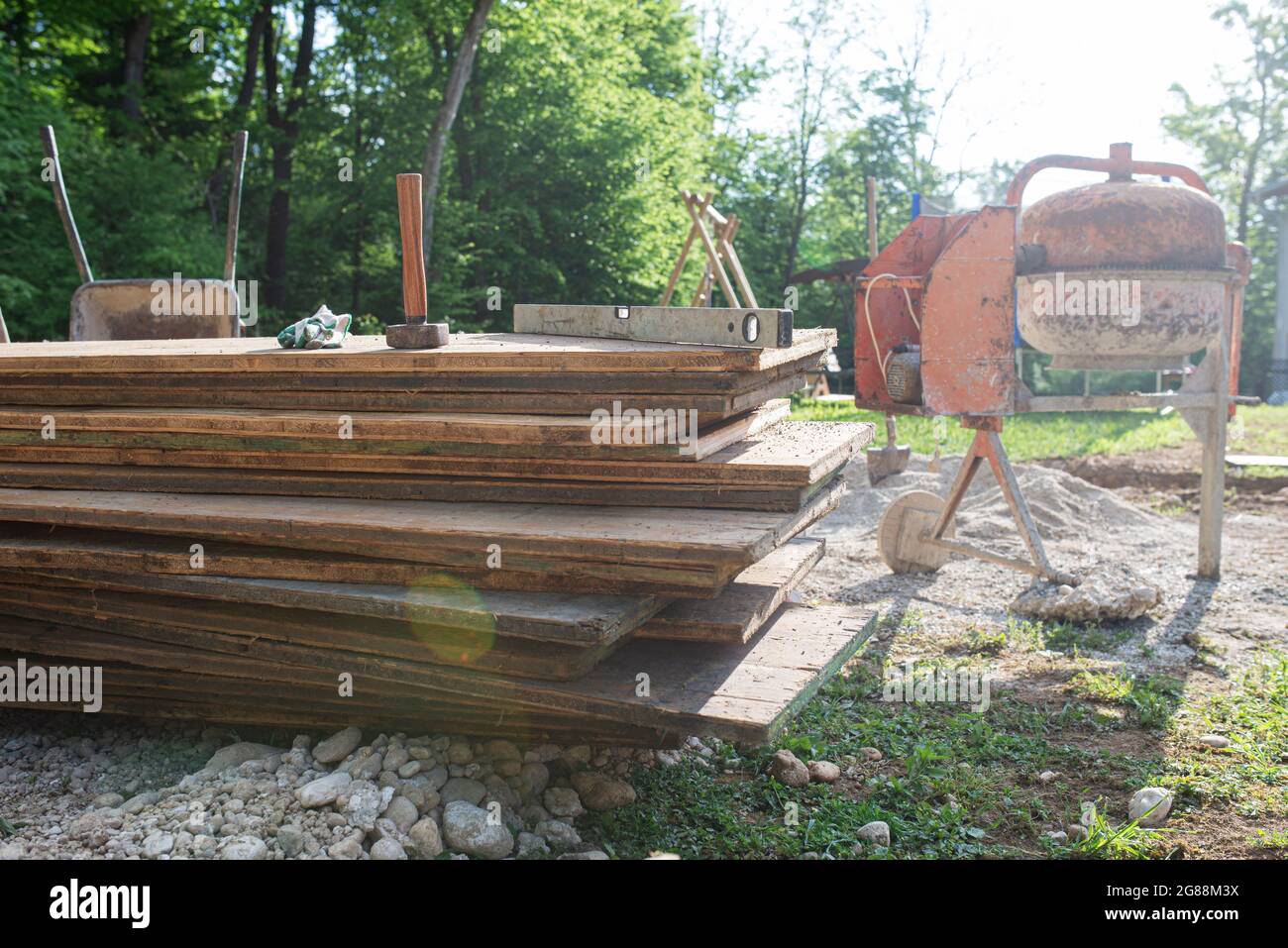 Construction site outside with a cement mixer, wooden panels and tools ...