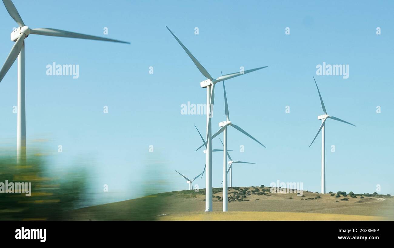 Wind generators spinning in operation viewed from a moving car Stock ...