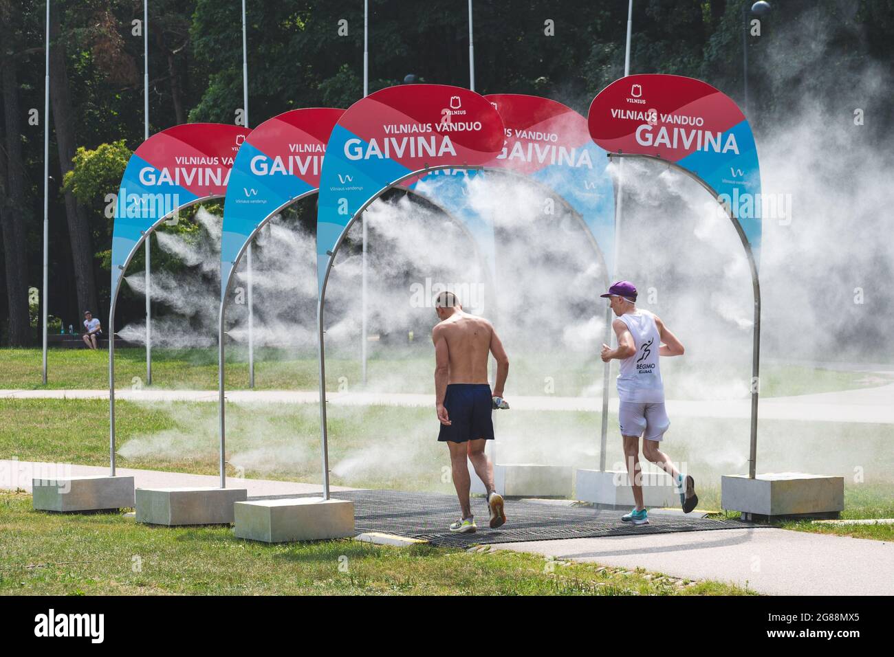 Athletes running through water mist to cool down during a competition ...