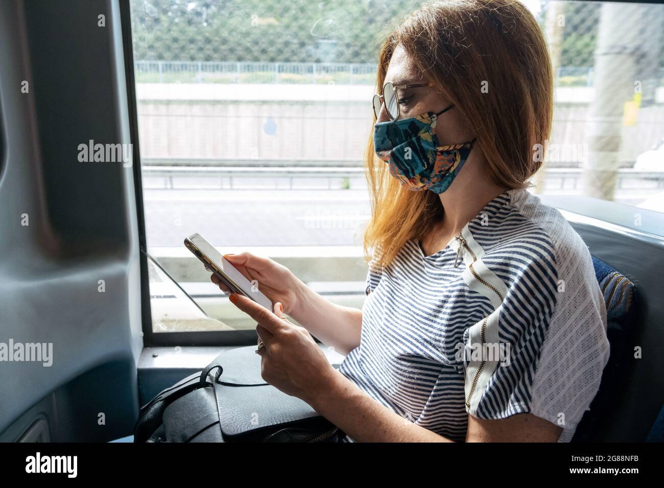 female passenger using phone inside the bus Stock Photo - Alamy
