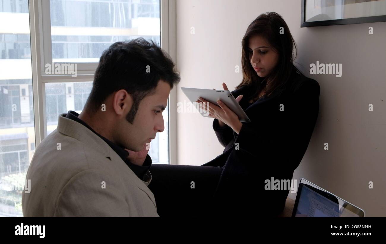 A closeup shot of two South Asian people working together in the office ...