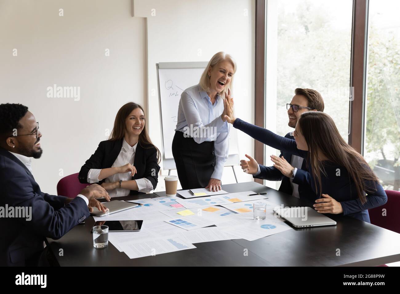 Happy mature mentor giving high five to Stock Photo - Alamy