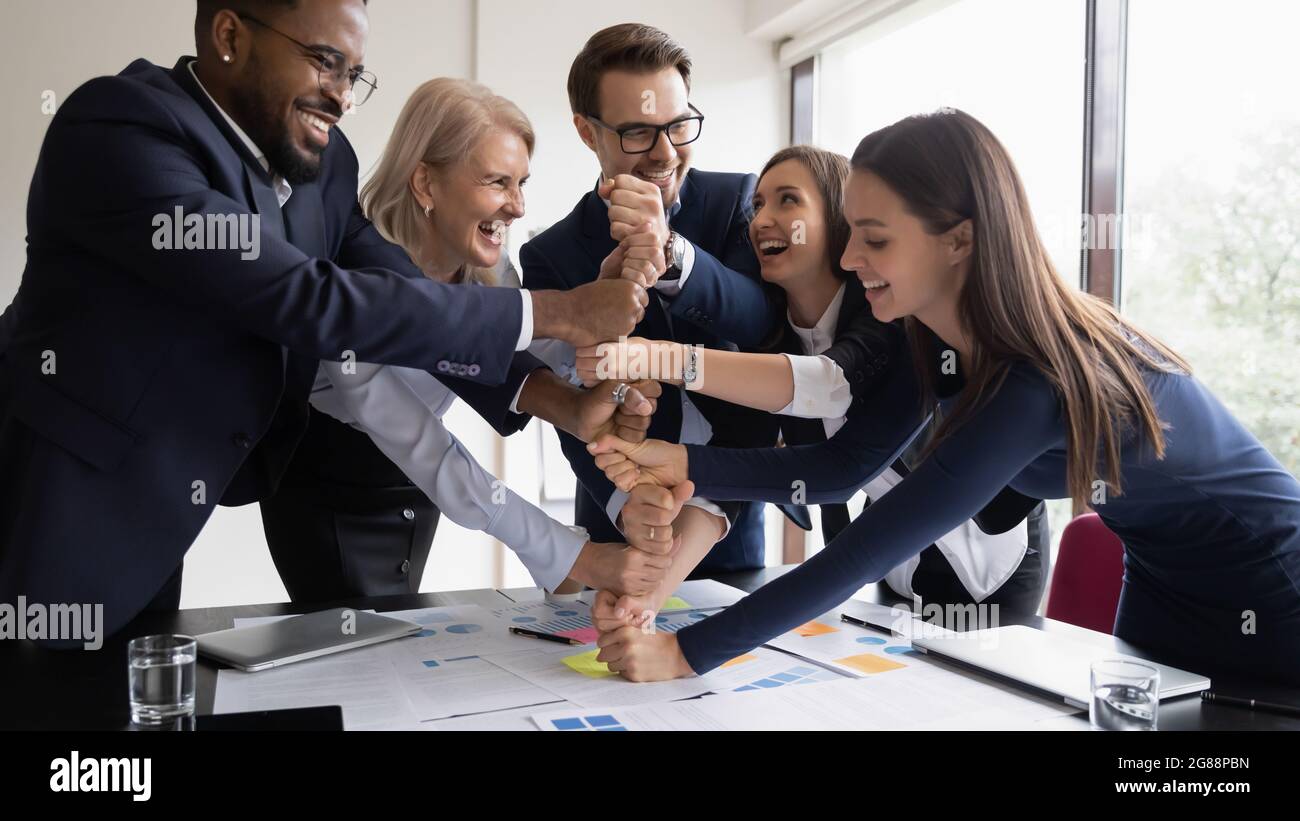 Happy excited business team of different ages employees celebrating ...