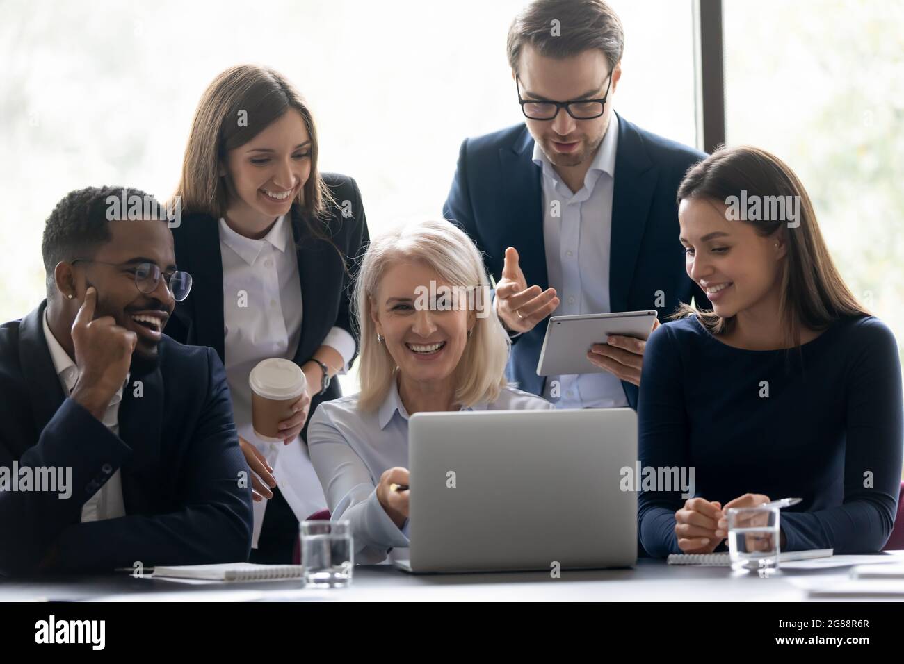 Happy senior mentor, coach teaching excited diverse interns Stock Photo ...