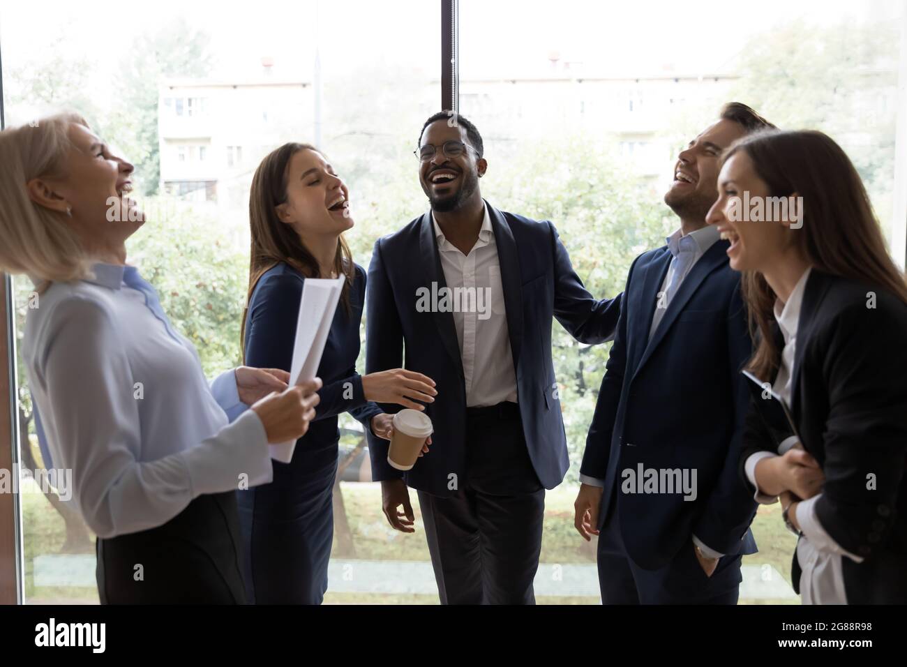 Happy relaxed diverse office colleagues having fun in hallway Stock ...