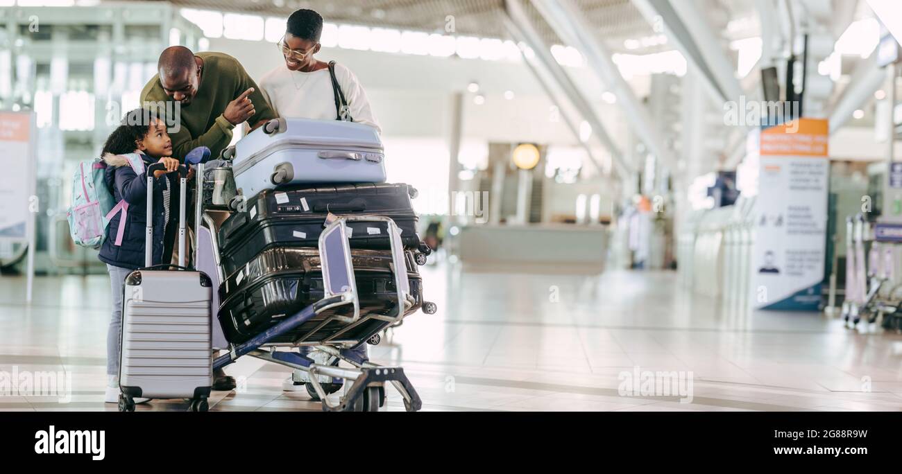 Wide angle shot of family waiting for their flight at airport. Parents ...