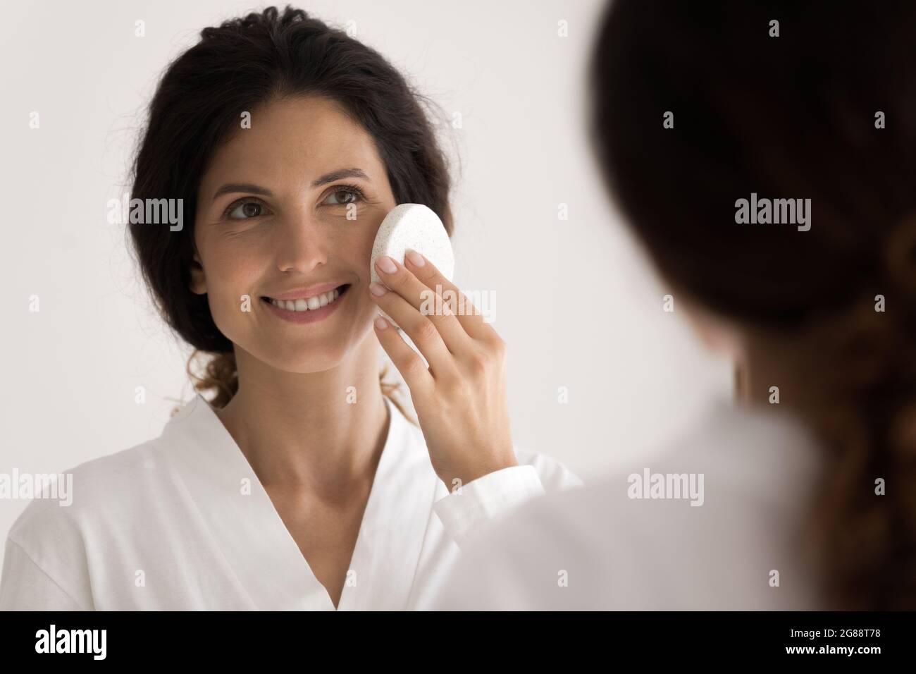 Millennial hispanic woman make tender face exfoliation by special ...