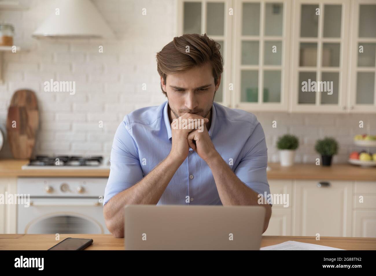 Serious young businessman work from home on laptop think hard Stock ...