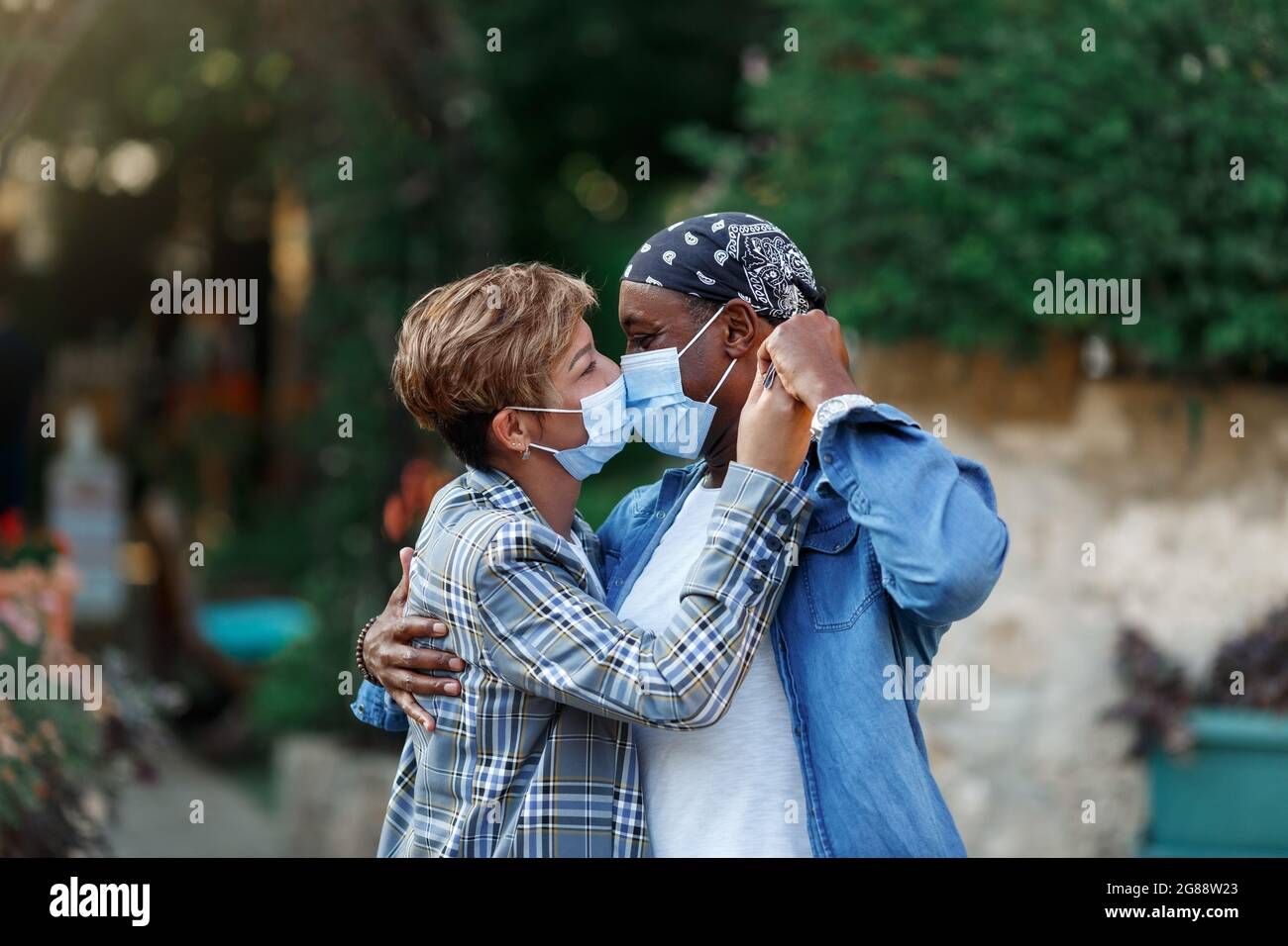 Couple of lovers wearing protective face mask kissing outdoor - New ...