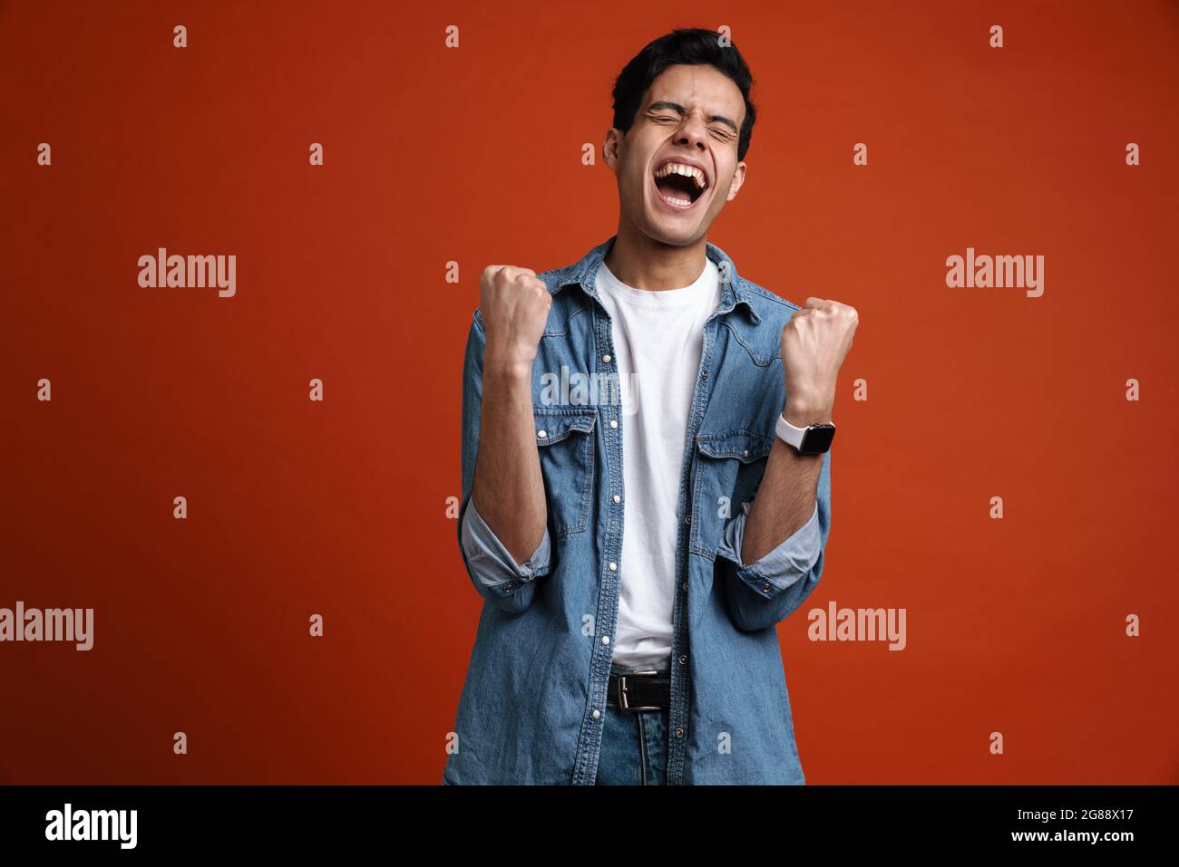 Excited hispanic man in shirt screaming while making winner gesture ...