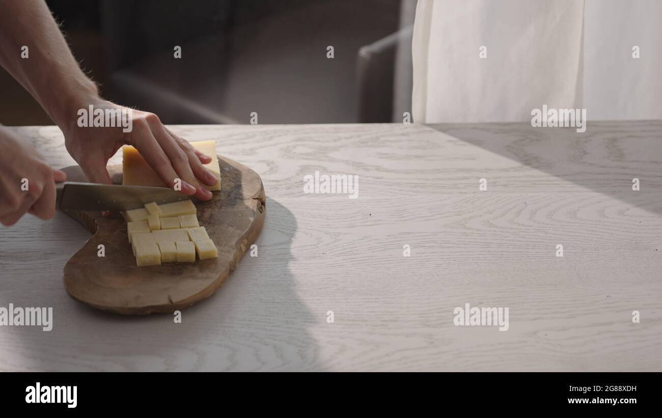 Man cutting vintage cheese on olive wood board, wide photo Stock Photo ...