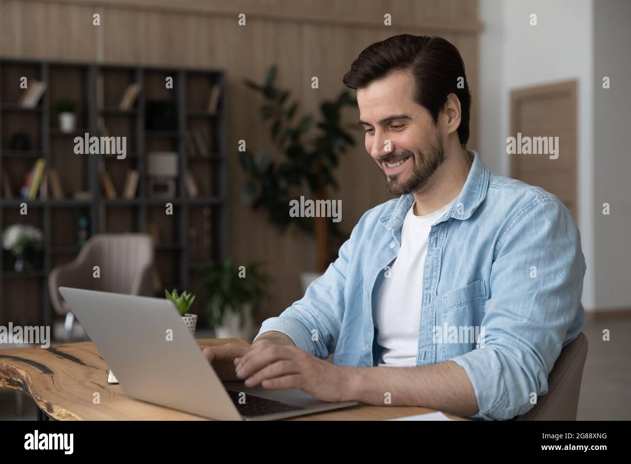 Happy millennial businessman working on online project on computer ...