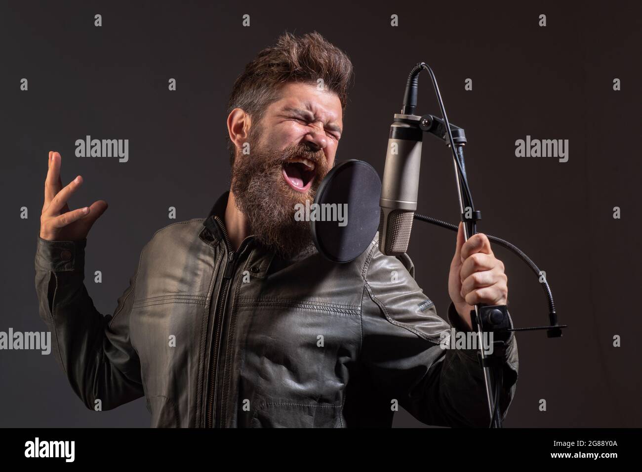 Singing man in a recording studio. Expressive bearded man with ...